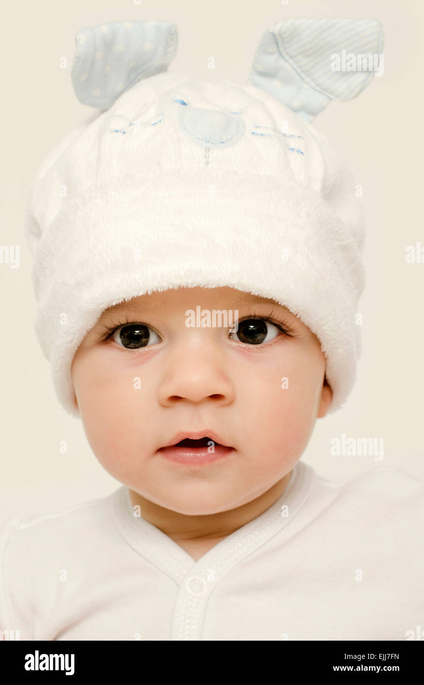 Innocent baby wearing a white hat looking adorable. Kid dressed for ...