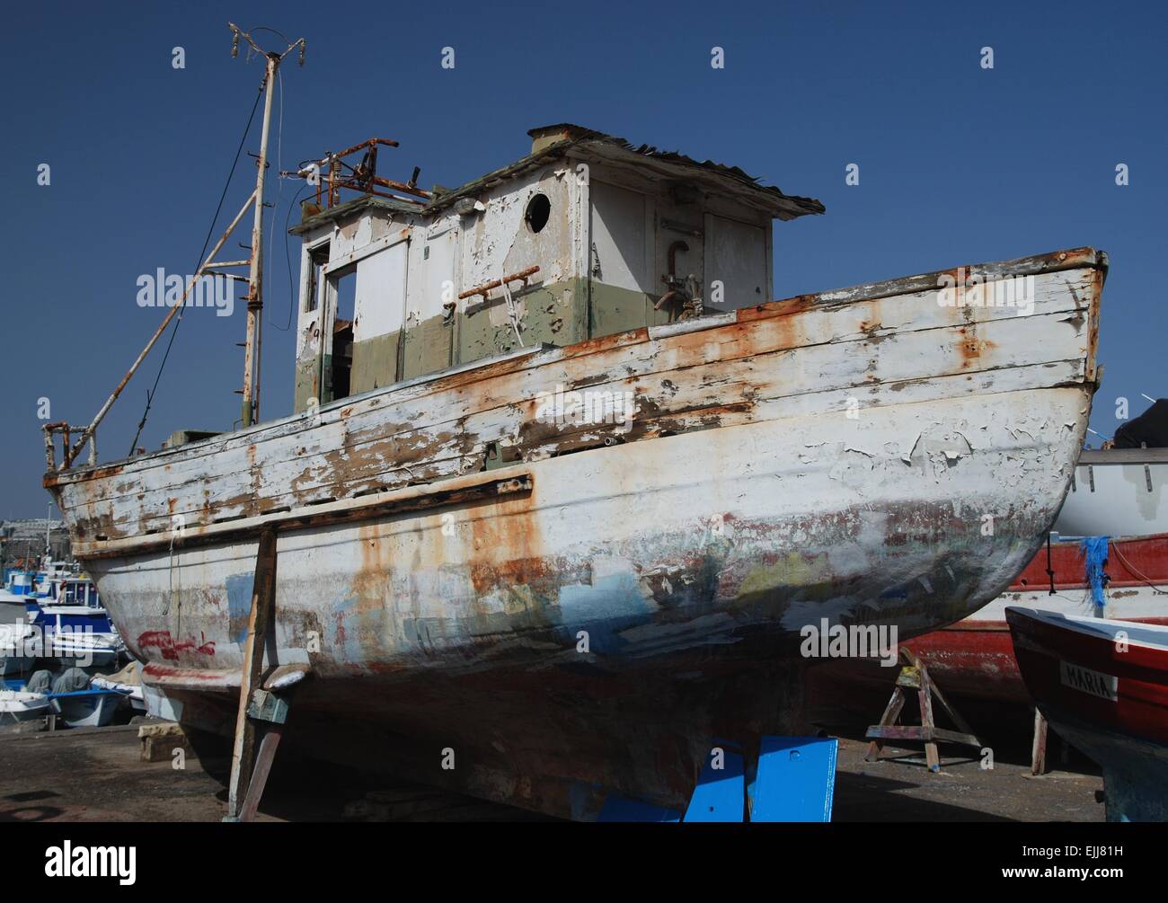 Rusty old fishing boat in a boatyard dry dock for a restoration project ...