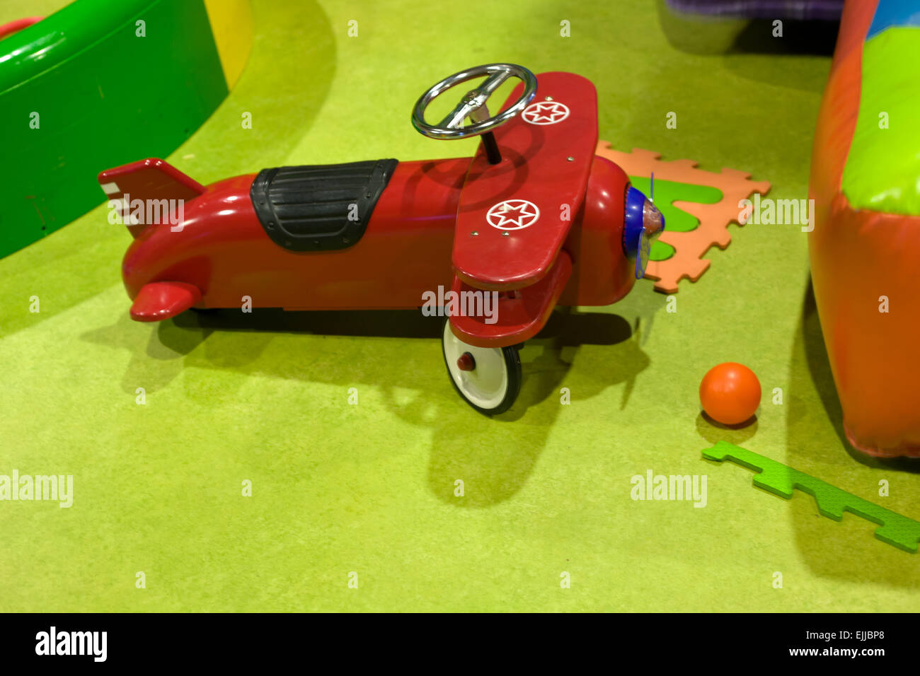 Red plane on preschool Kindergarten colorful toys area Stock Photo - Alamy