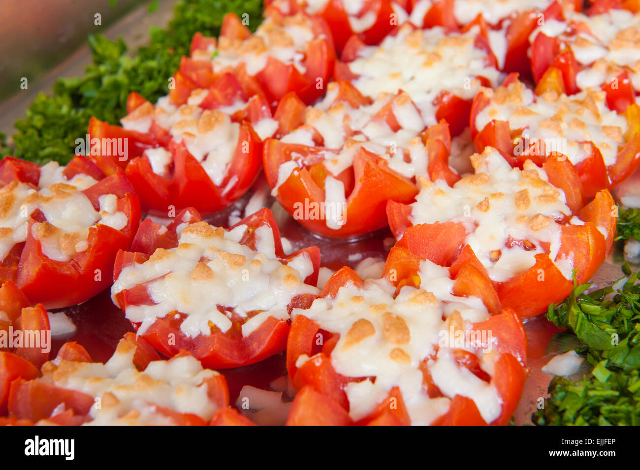 Closeup of cooked tomatoes with melted cheese on display at a hotel ...