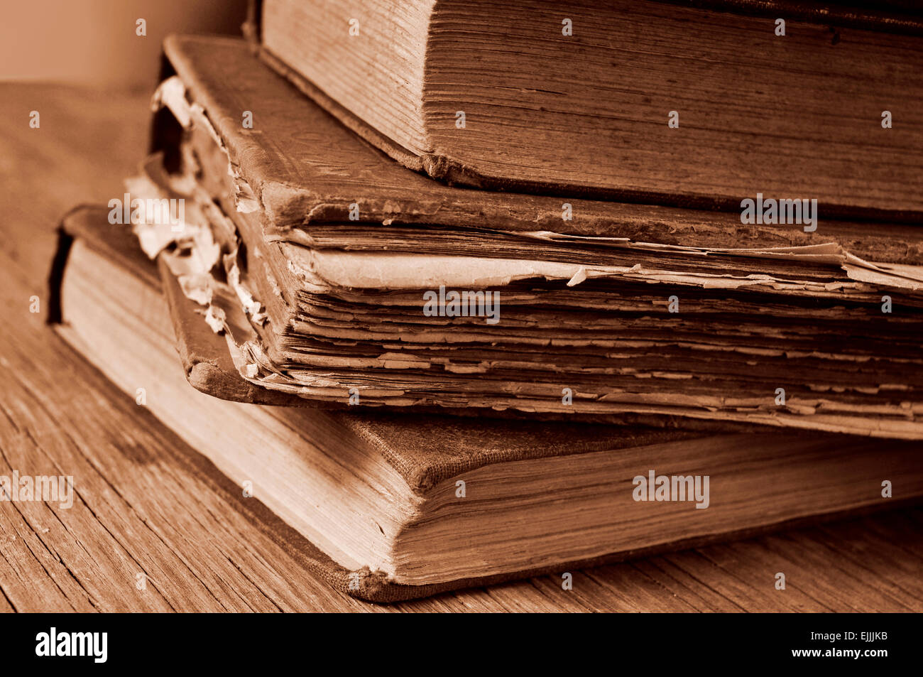 closeup of a pile of worn-out old books on a rustic wooden table, in sepia toning Stock Photo ...