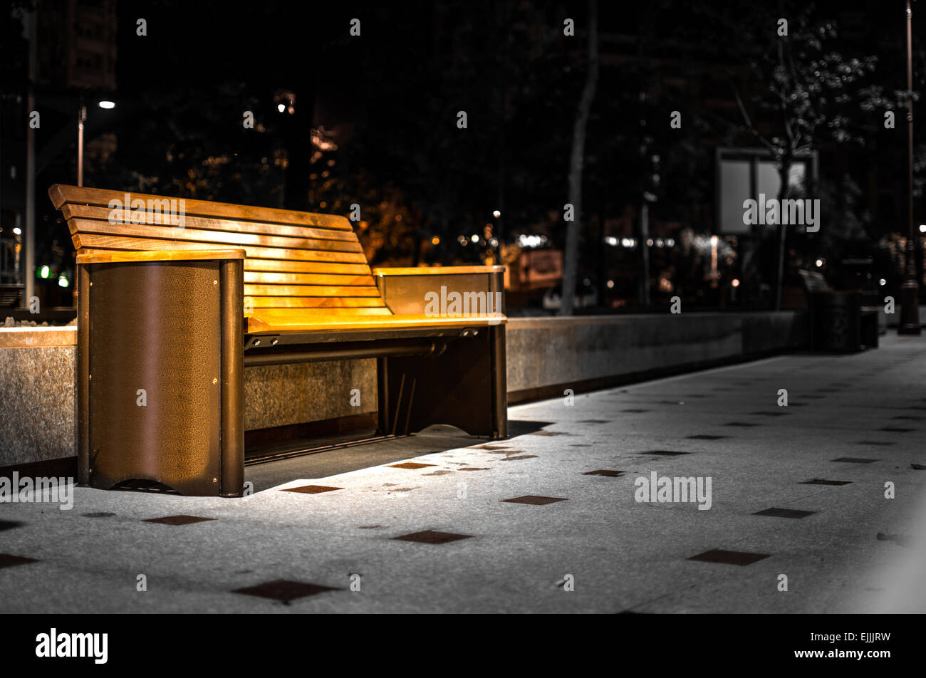 Lit bench on sidewalk at night Stock Photo - Alamy
