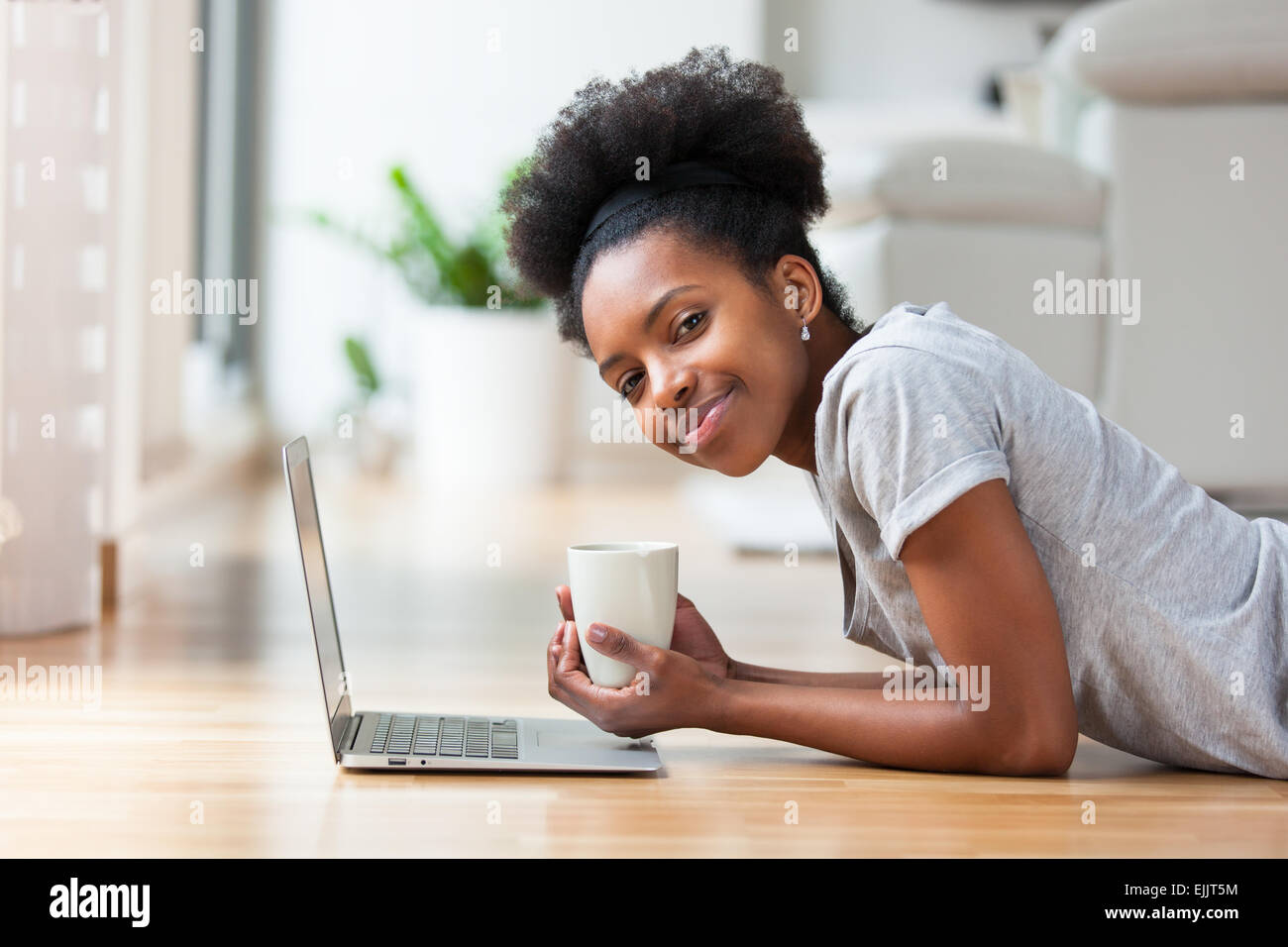 African American woman using a laptop in her living room - Black people ...
