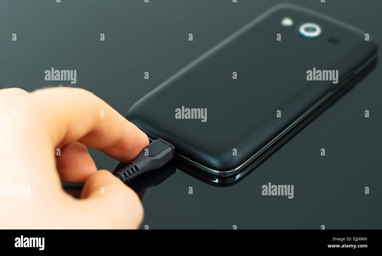Male hand inserting micro USB to mobile phone Stock Photo - Alamy