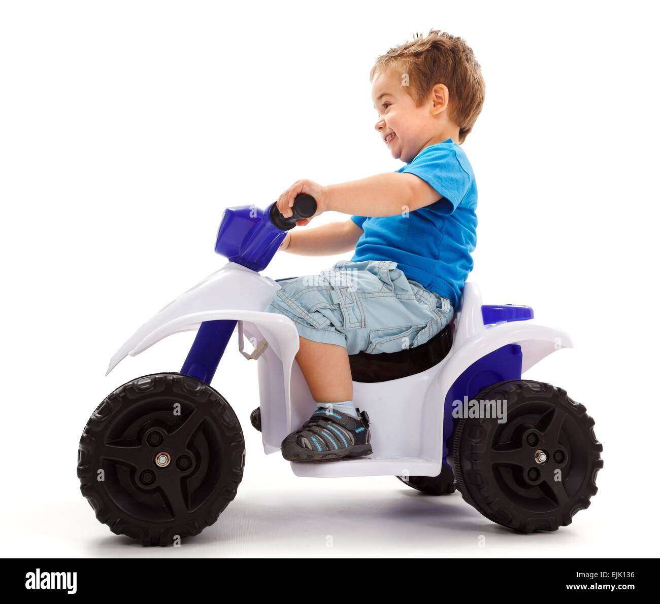 Little boy going fast with a little toy quad Stock Photo - Alamy