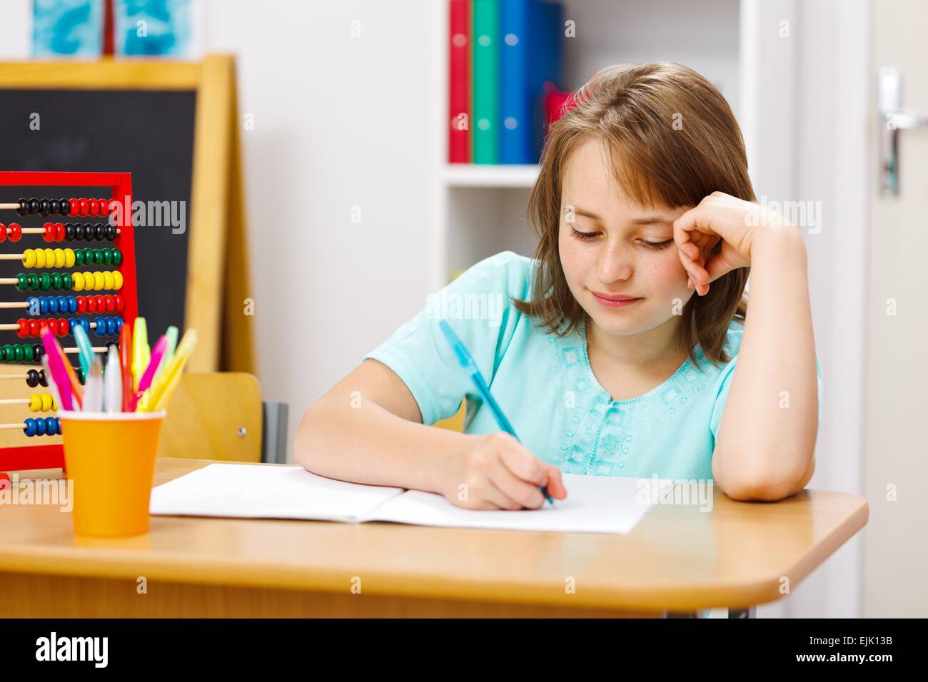 Schoolgirl practicing and writing homework in classroom Stock Photo - Alamy