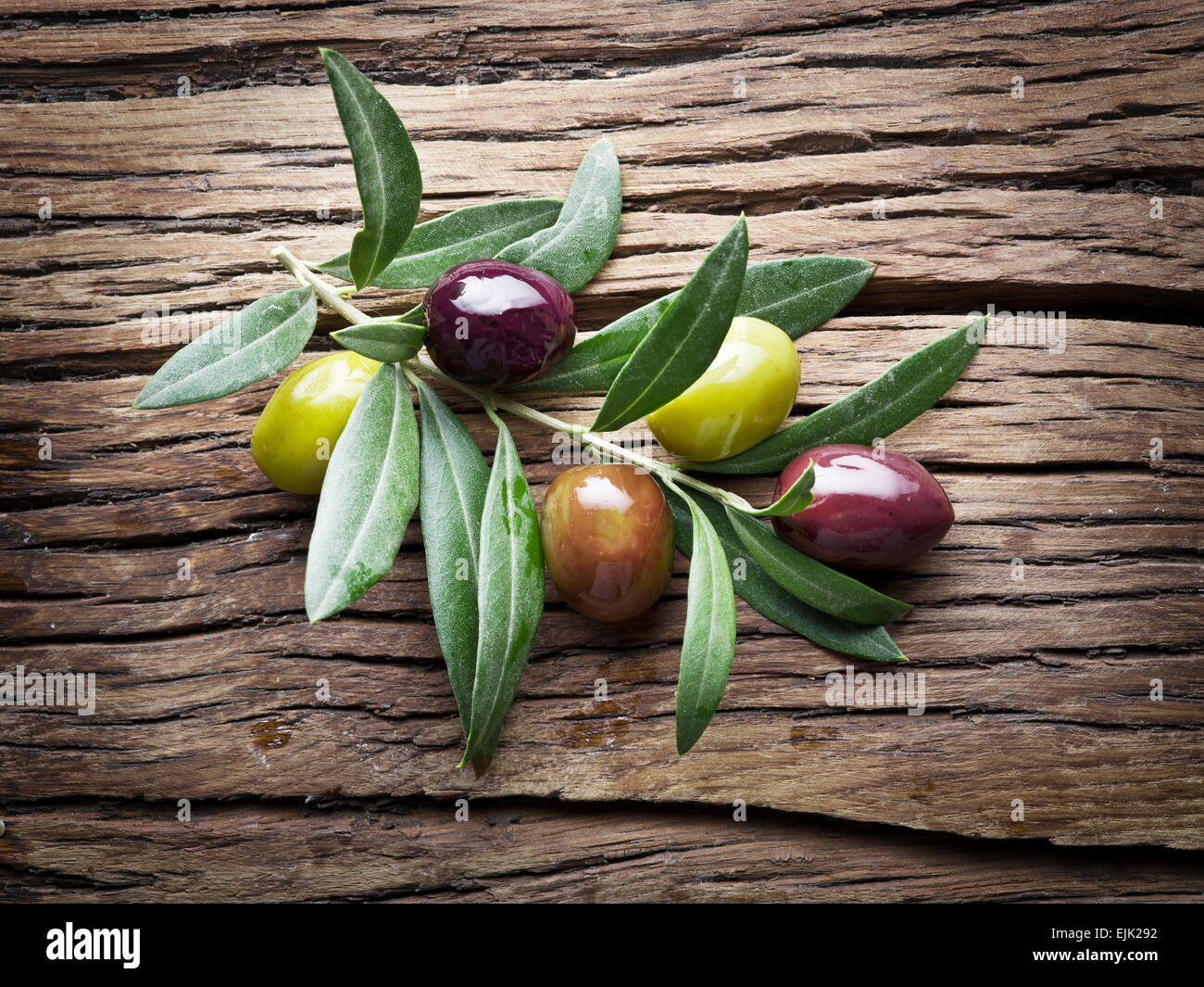 Olive twig on old wooden table Stock Photo - Alamy