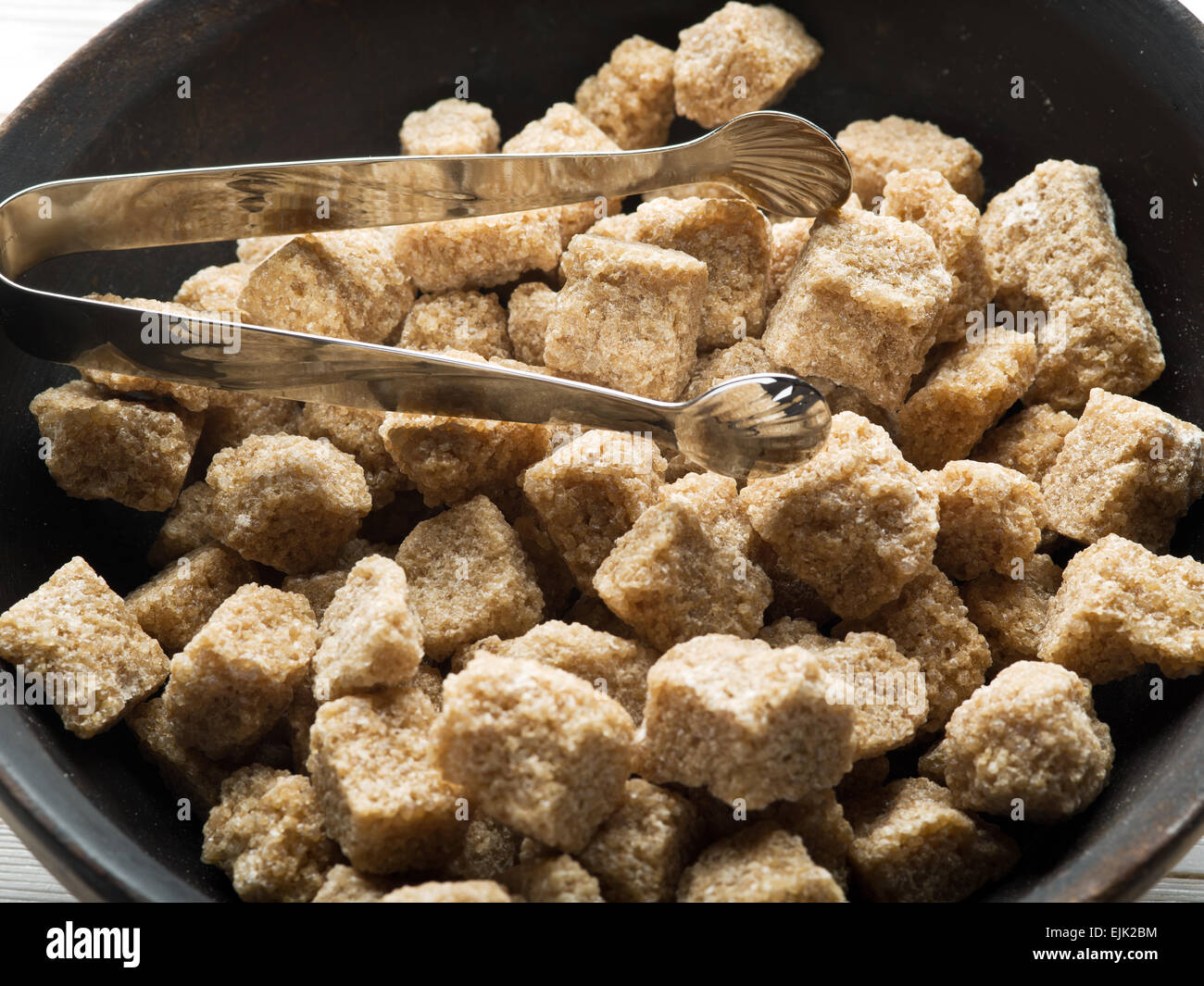 Cubes of cane sugar on blue wooden table Stock Photo - Alamy