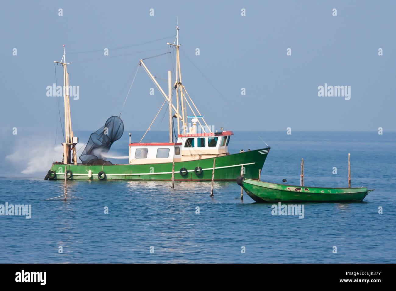 Fishing ship cleaning the nets Stock Photo - Alamy