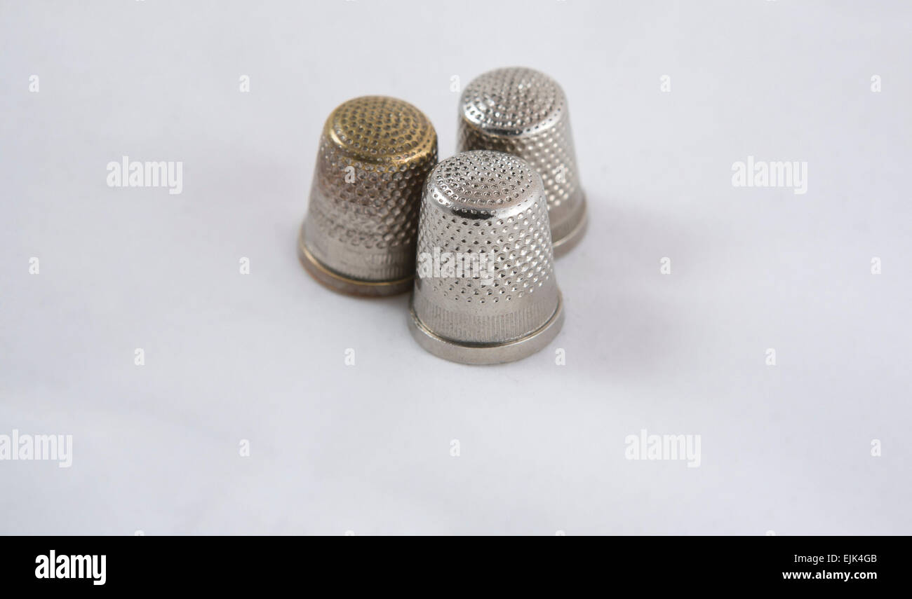 Three metal thimbles isolated over white background Stock Photo - Alamy