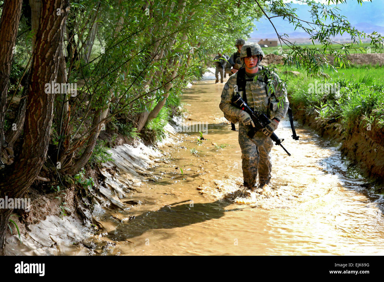 U.S. Army Soldiers wade through a small creek while conducting a ...