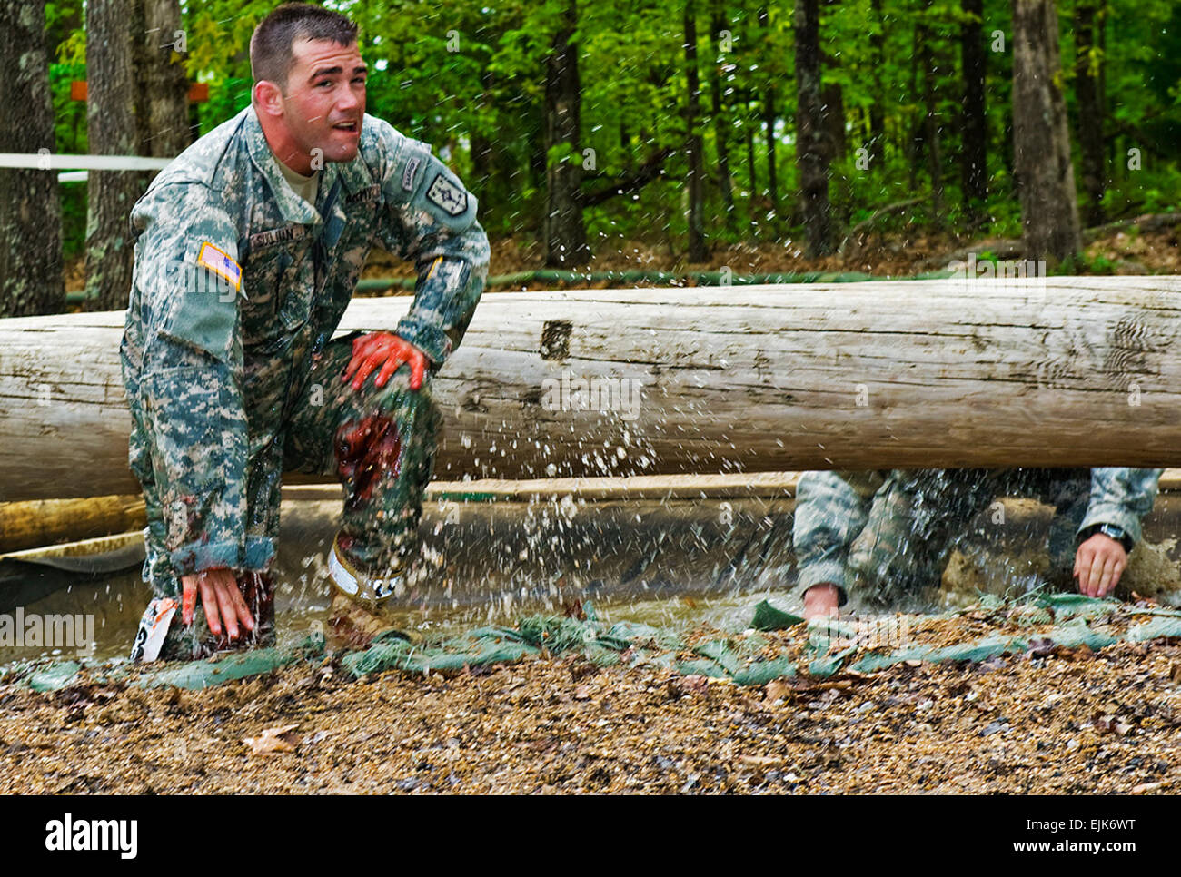 Two sapper competitors emerge from a water-filled pit as they traverse ...