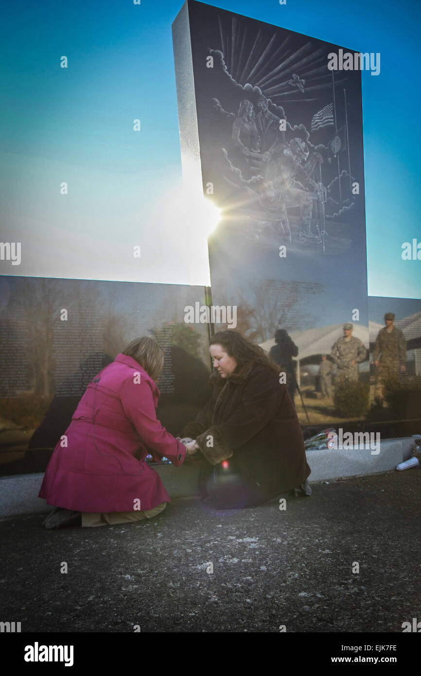 Michelle Leibold and her sister Amy Lawrence say a prayer while ...