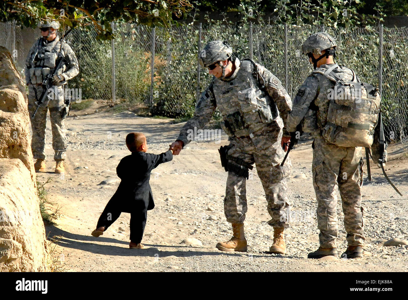 U.S. Army Lt. Col. Jeff Cantor shakes the hand of an Afghan boy outside ...