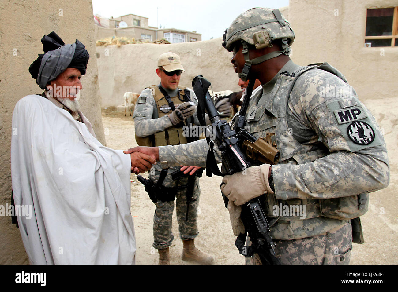 U.S. Army Staff Sgt. Michael Baldwin shakes hands with an elder in the ...