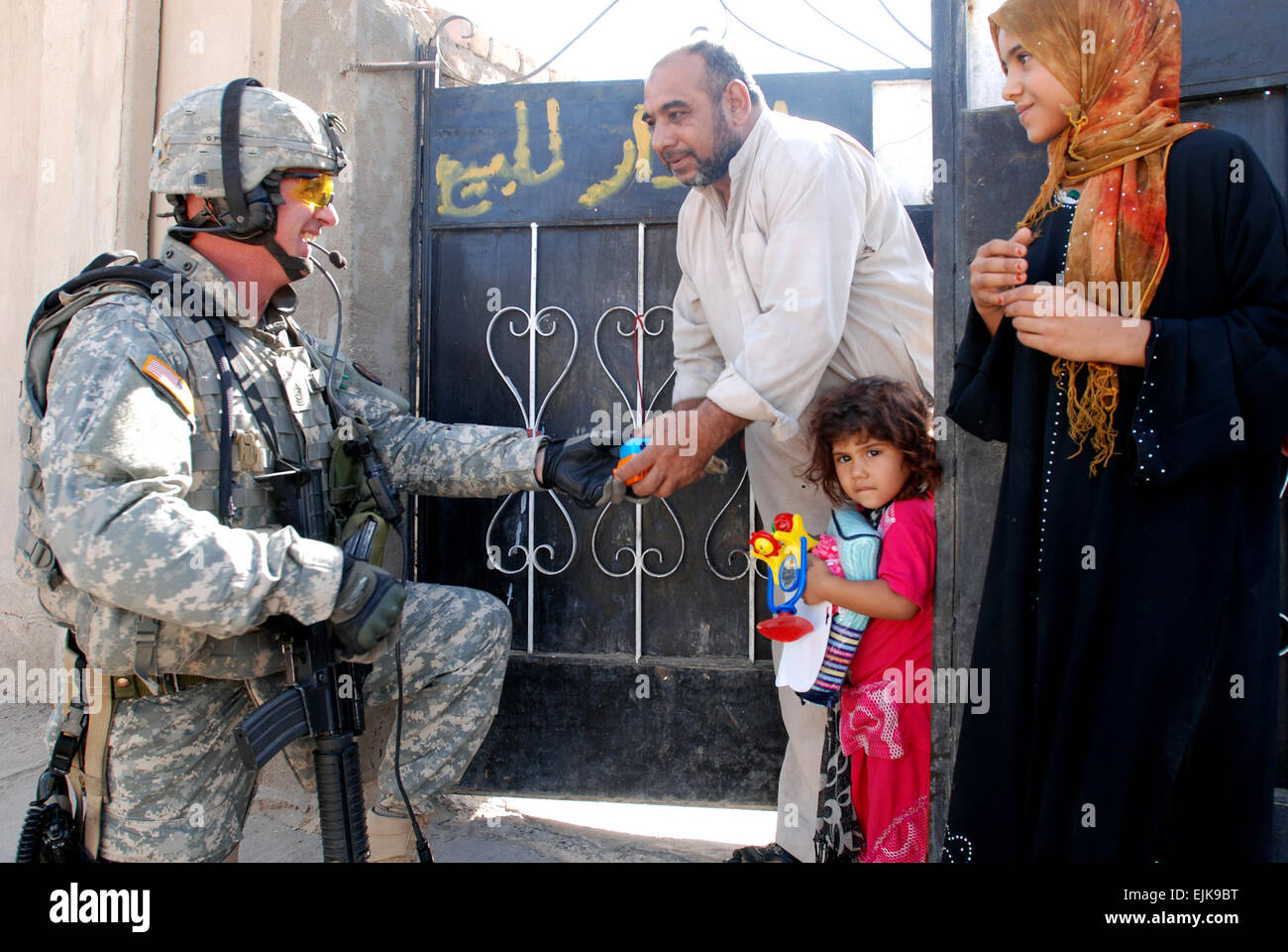 Multi-National Corps - Iraq Command Sgt. Maj. Neil Ciotola distributes ...