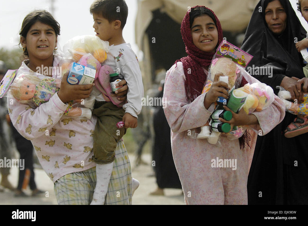 Iraqi children walk with toys they received during a combined medical ...