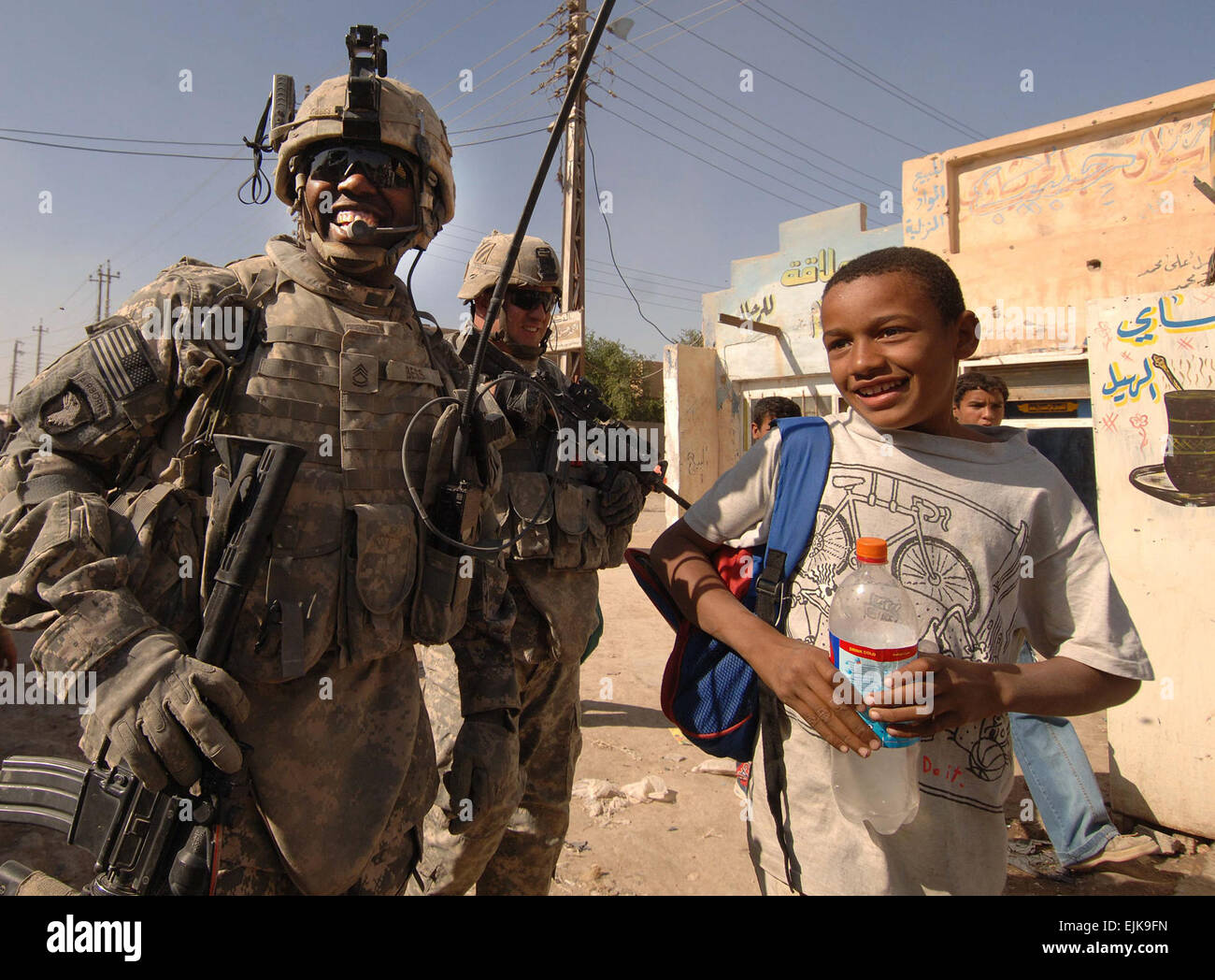 U.S. Army Sgt. 1st Class David Bess provides jokes with an Iraqi child ...