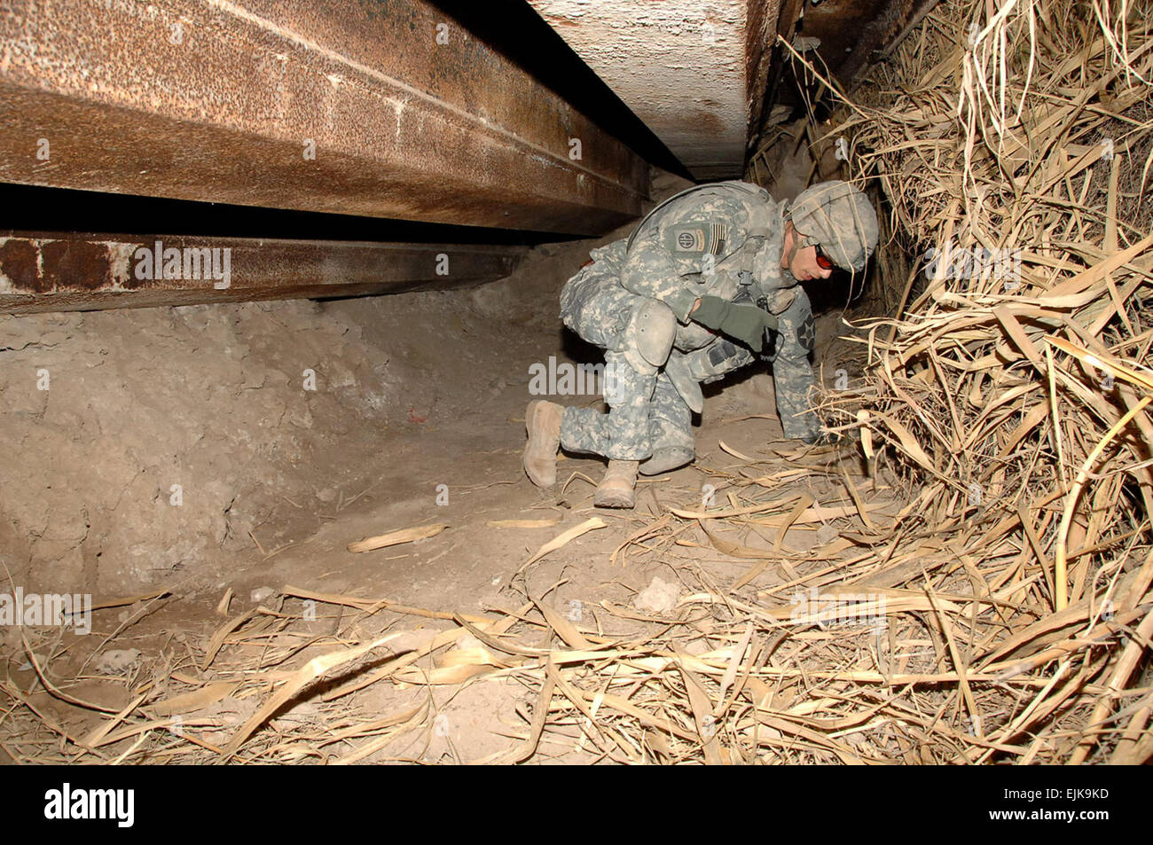 A U.S. Army Soldier searches for weapons caches or evidence of ...