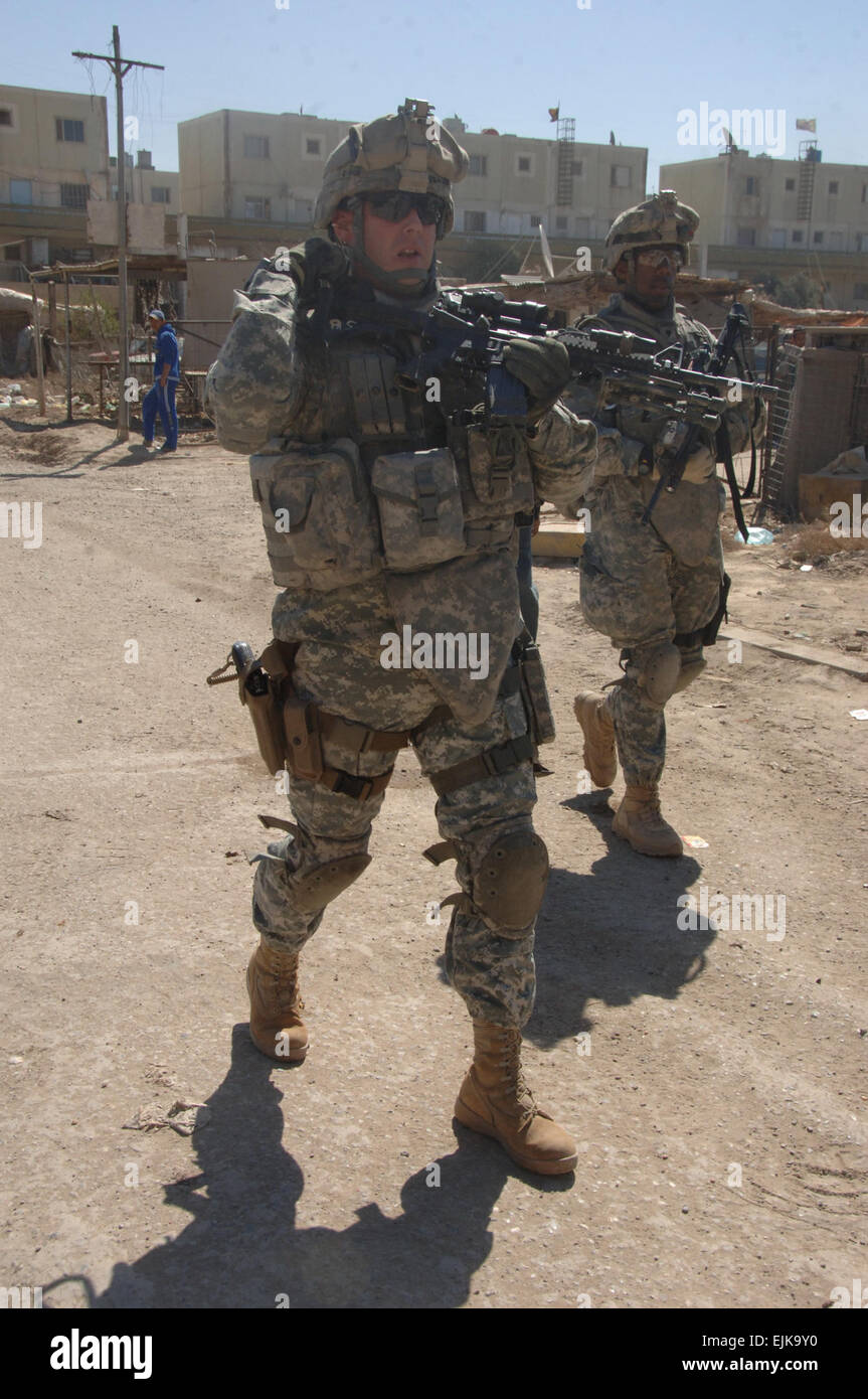 U.S. Army Command Sgt. Maj. Frank Wood and a fellow Soldier provide ...