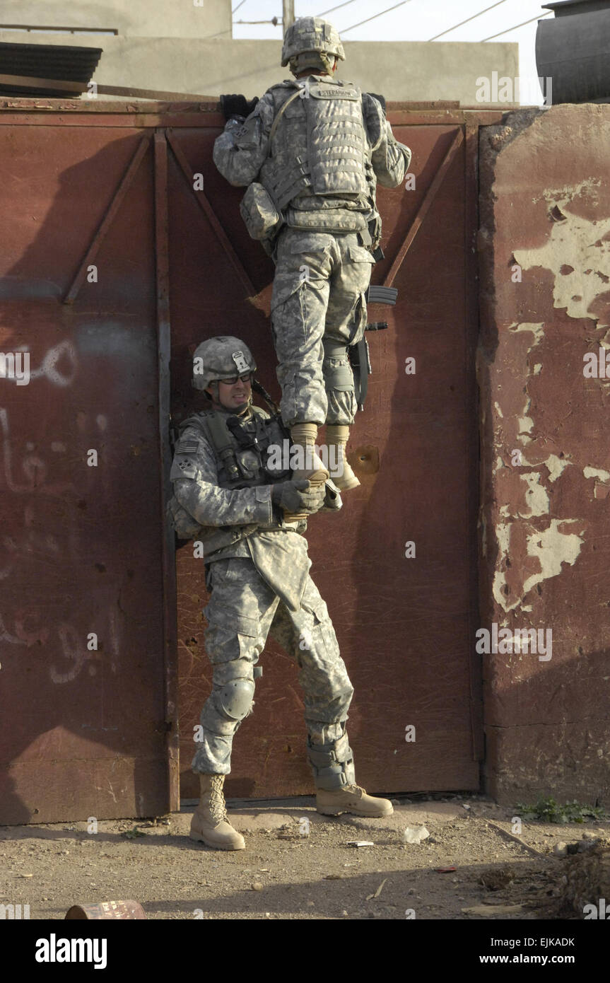 U.S. Army 1st Sgt. Shane Chapman gives another soldier a boost in order ...