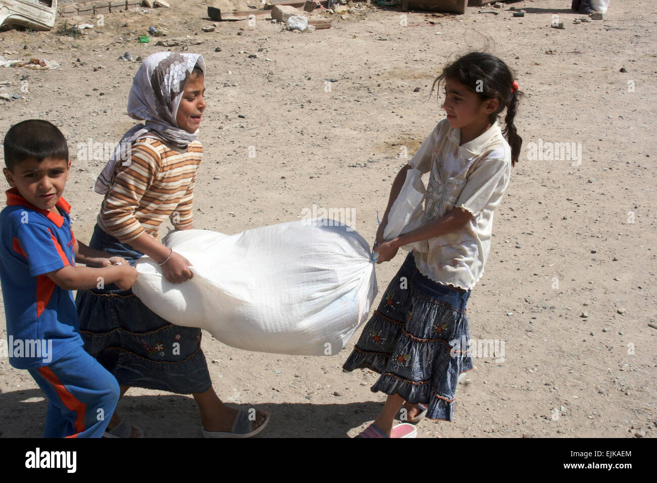Children carry a bag of food they received from Iraqi police in ...