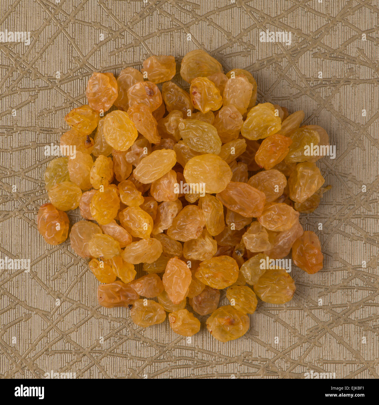 Top view of circle of golden raisins against green vinyl background ...