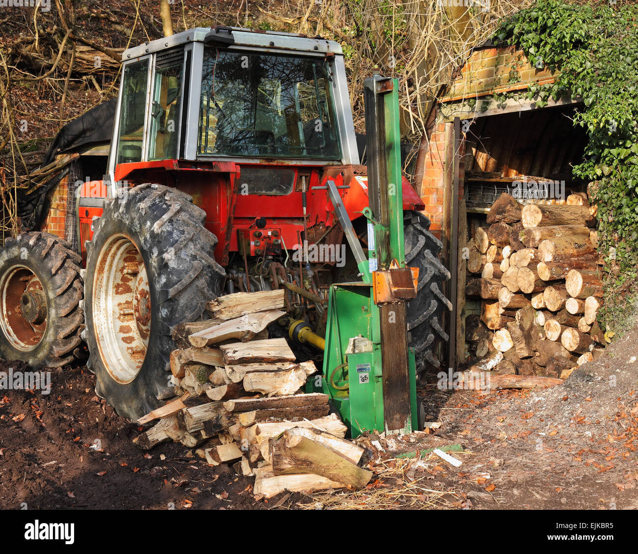 Pile of Logs and log splitter attached to a tractor Stock Photo - Alamy