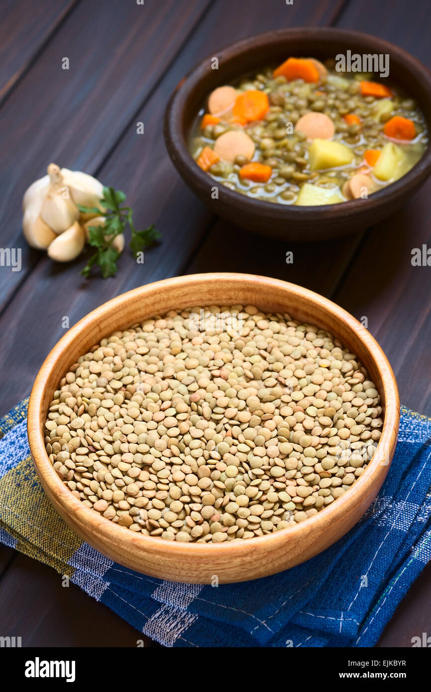 Raw lentils (lat. Lens culinaris) in wooden bowl with a rustic bowl of ...