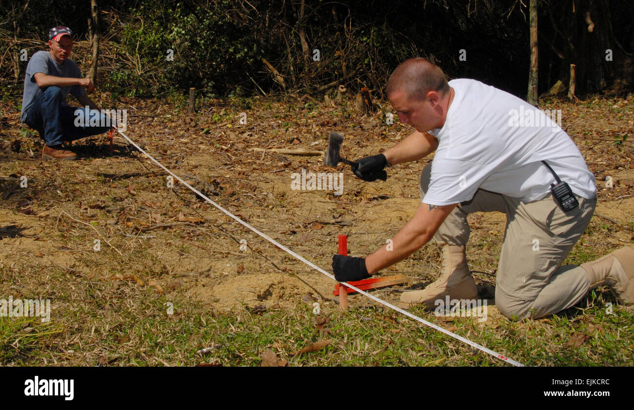 U.S. Air Force Staff Sgt. Christopher Gremling pounds in a grid stake ...