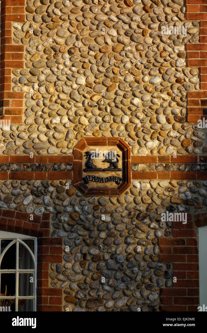 Detail of beach pebble built cottage with brick trim and estate crest ...