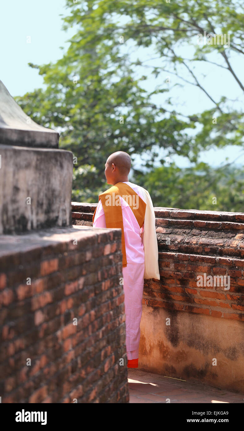Buddhist monk photographed from behind in white and yellow clothes ...