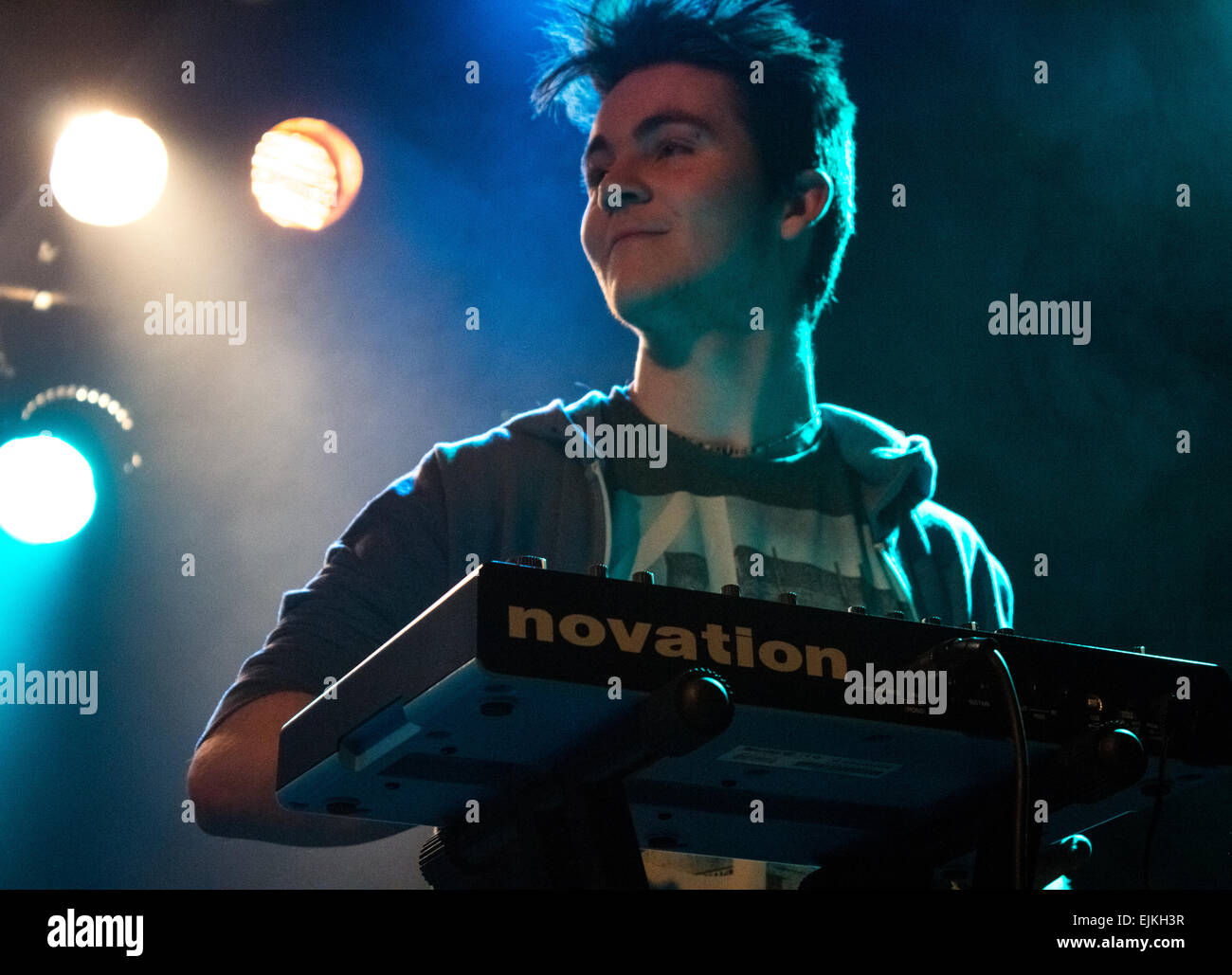Man in a band on stage smiling and playing a Novation synth Stock Photo ...