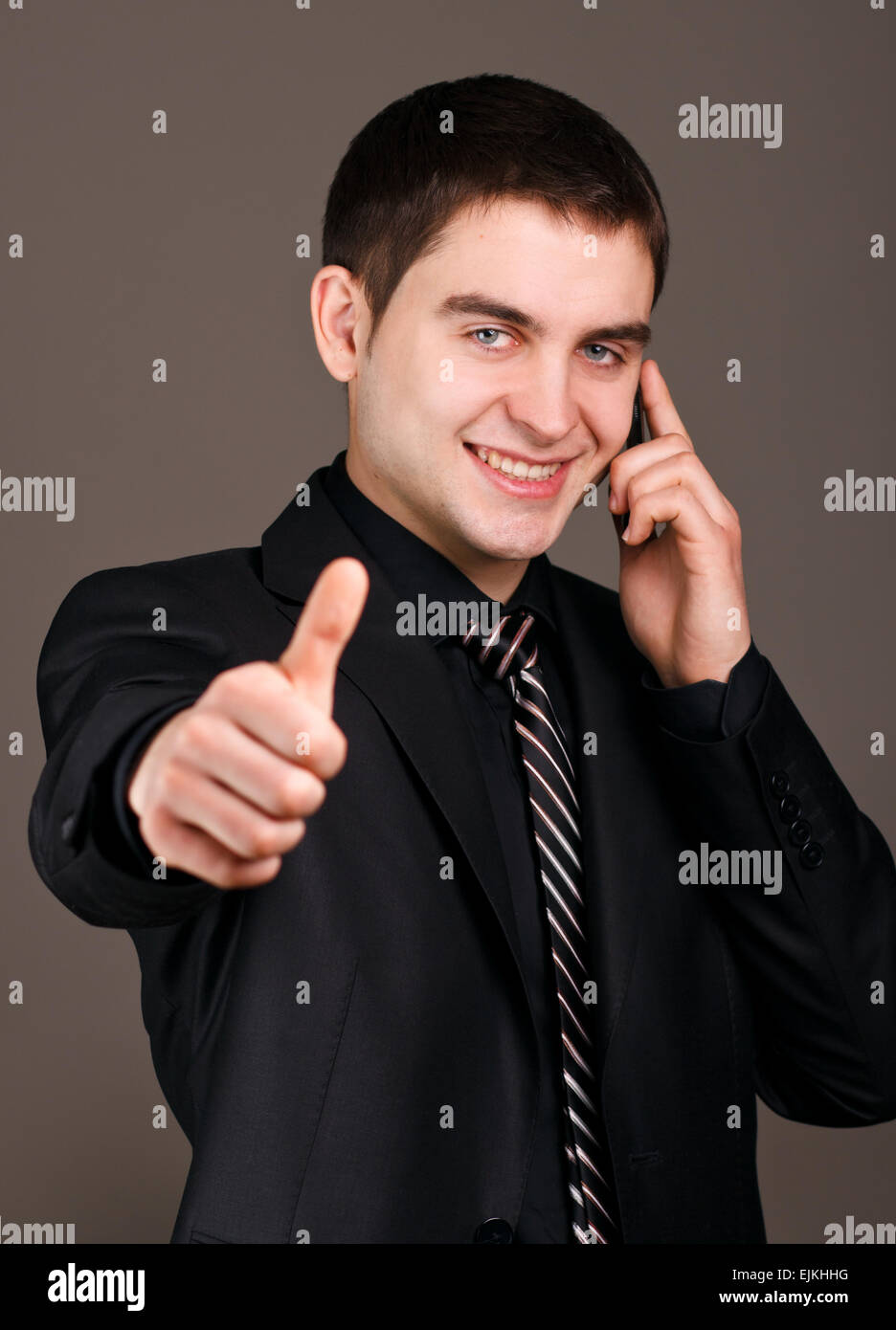man talking on phone showing thumb Stock Photo - Alamy