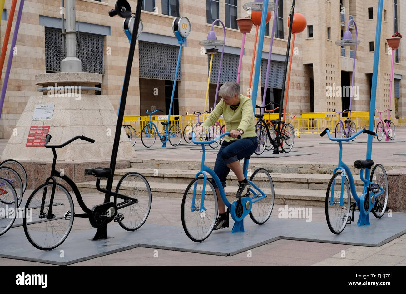 An elderly woman riding a pedal powered music machine bicycle in an ...