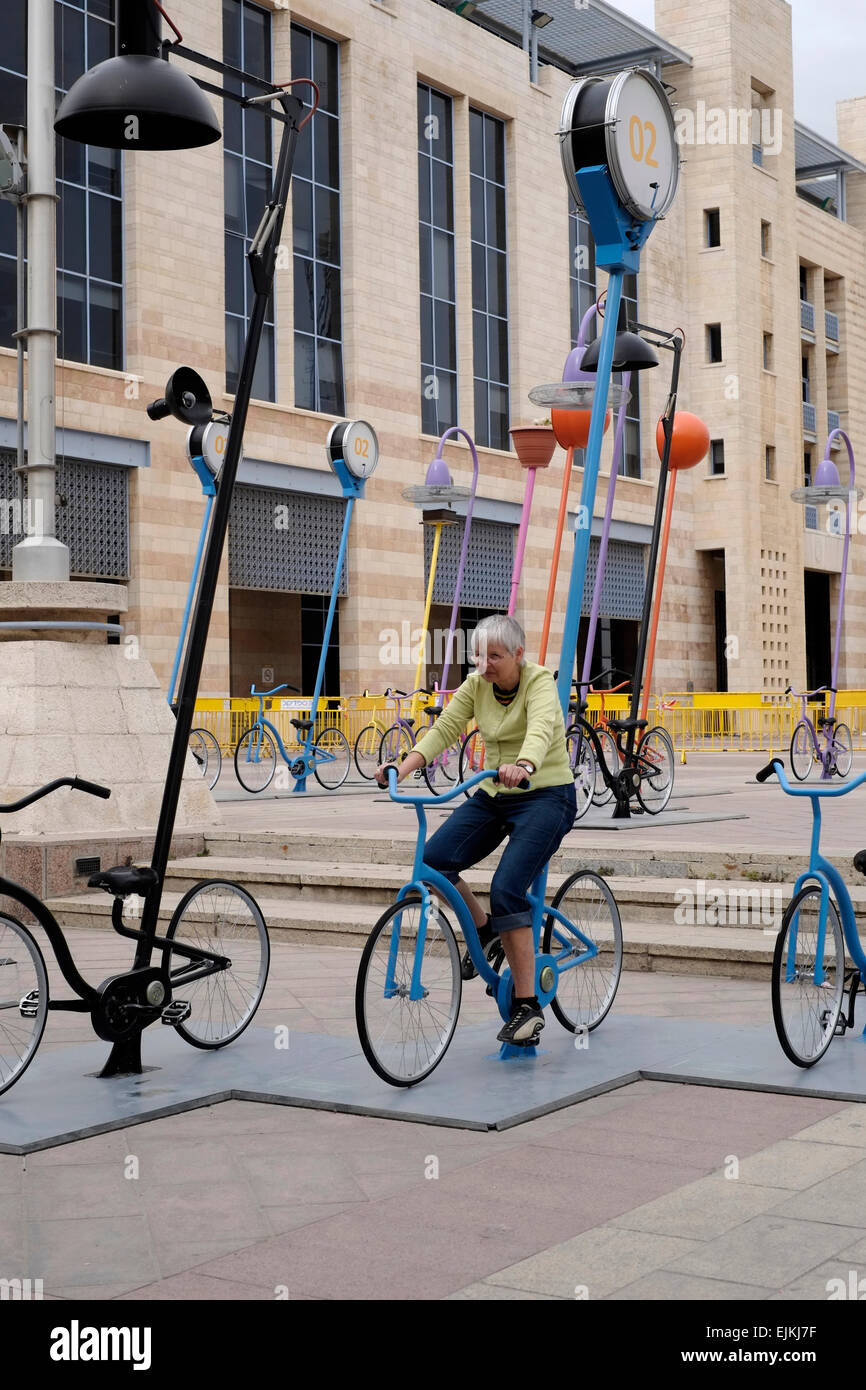 An elderly woman riding a pedal powered music machine bicycle in an ...