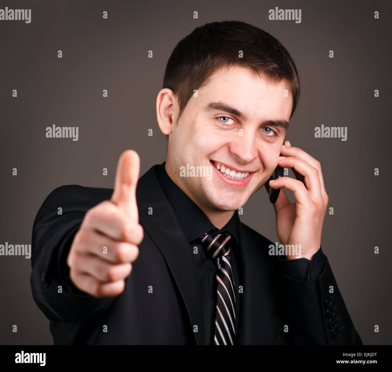 man talking on phone showing thumb Stock Photo - Alamy