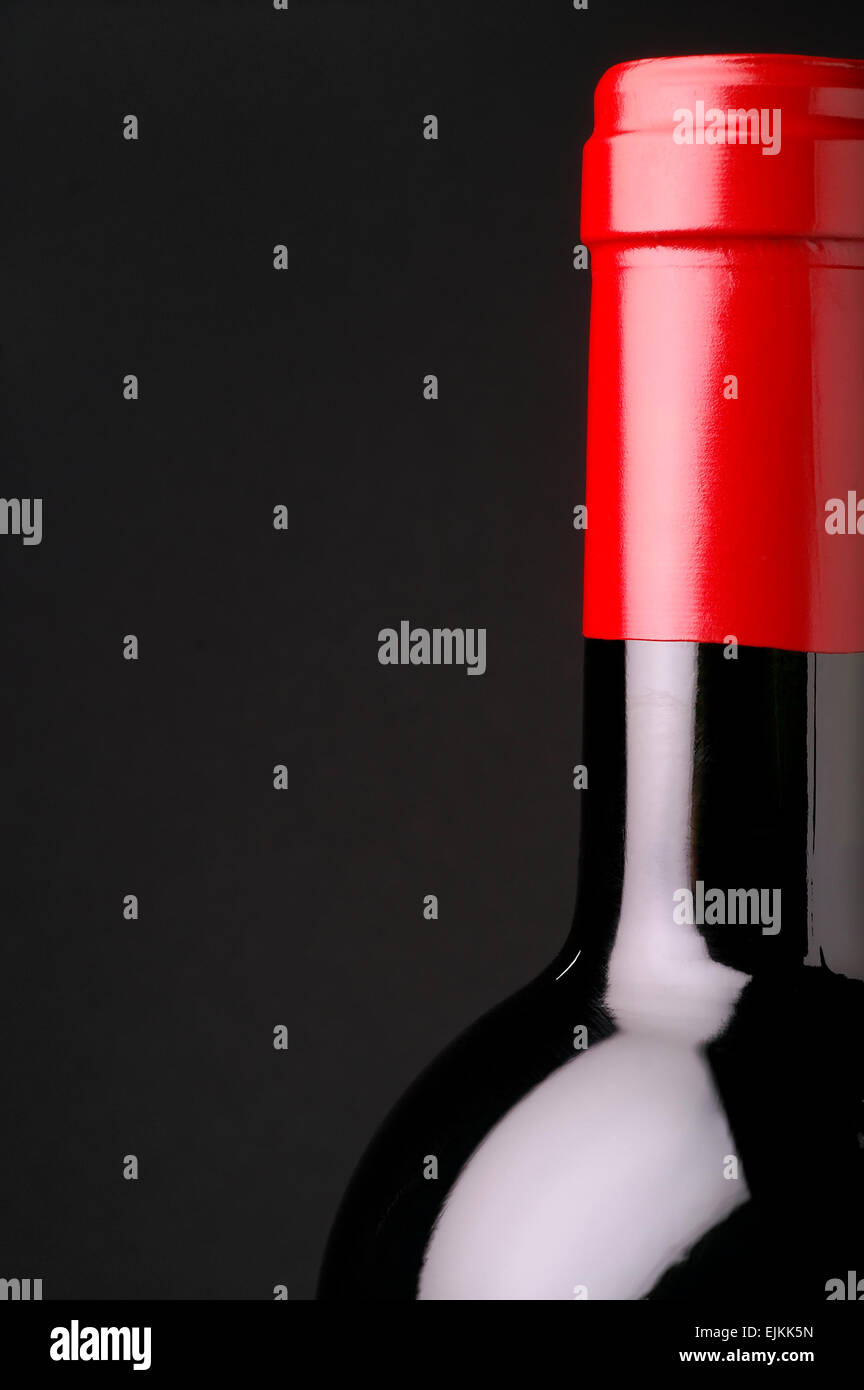 Red wine bottle closeup with red capsule and black background Stock ...