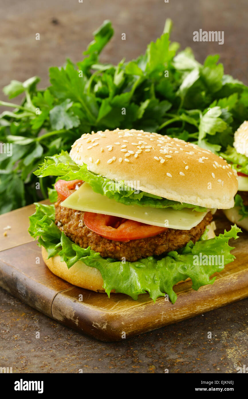 traditional cheeseburger with green lettuce and tomatoes Stock Photo ...