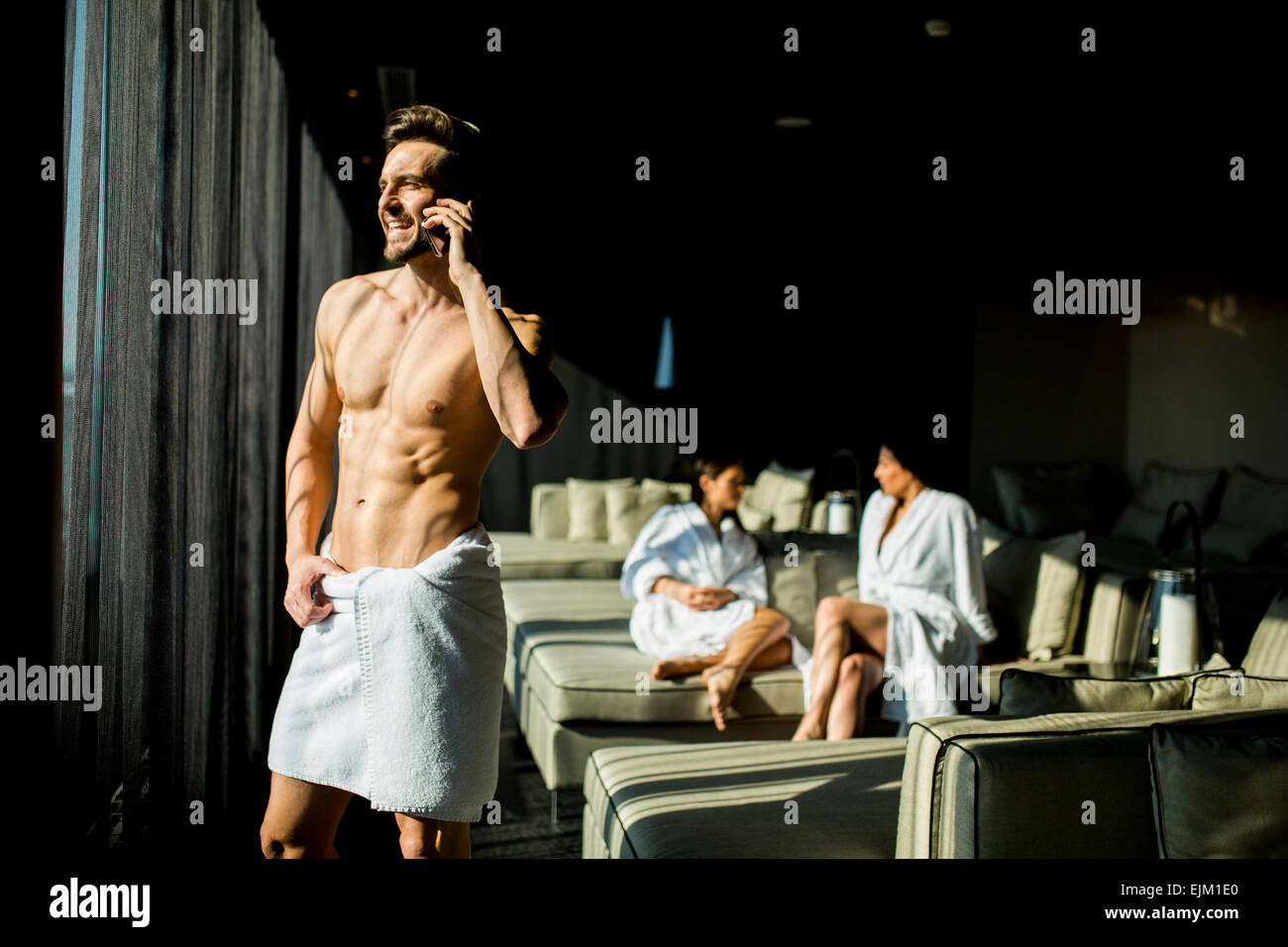 Young man in the rom with two women Stock Photo - Alamy