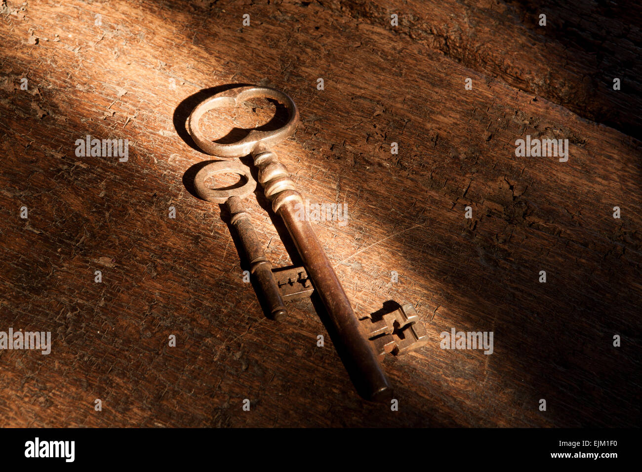 Light beam falling on rusty keys on very old wood Stock Photo - Alamy