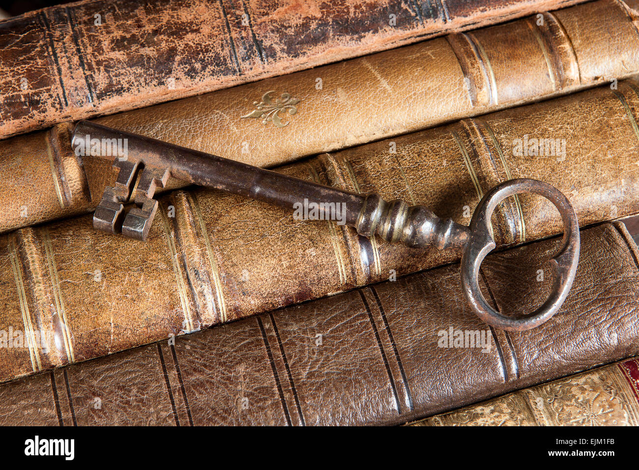 Large rusty key lying on weathered old books Stock Photo - Alamy