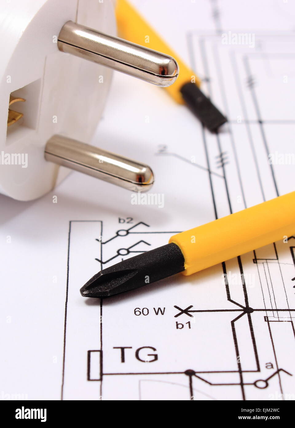 Screwdriver, work tools and electric plug lying on construction drawing ...