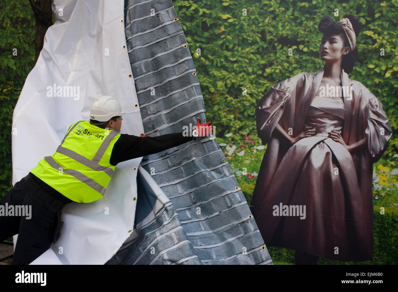 A workman from Stewart Signs organises the hanging of a temporary ...