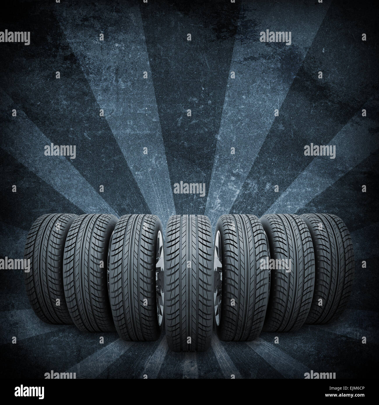 Wedge of new car wheels. Background is concrete surface and stripes at ...