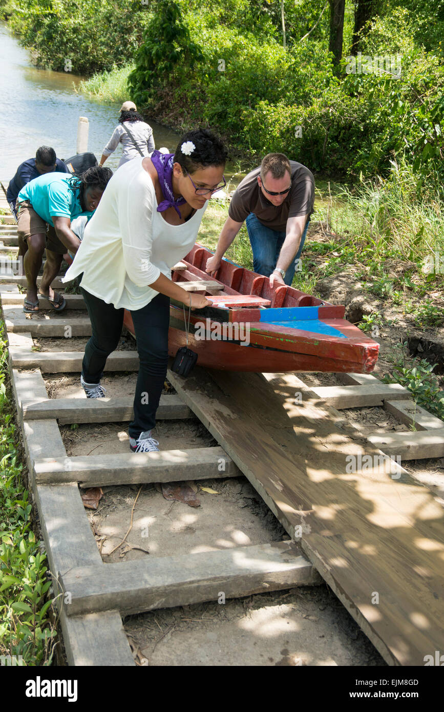 Tourists pushing the boat in the Matapica channel, Suriname Stock Photo ...