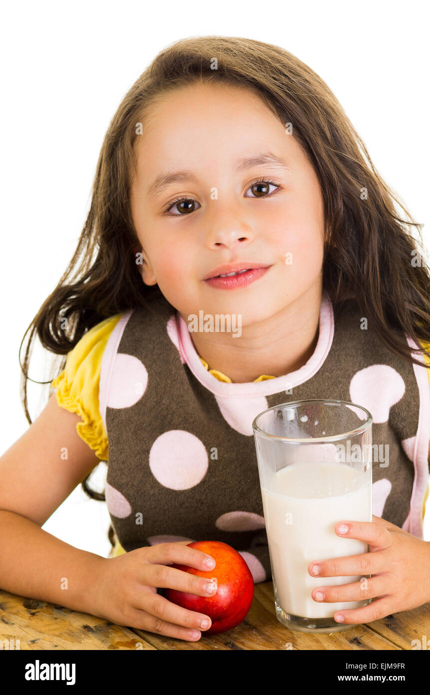 Cute little preschooler girl drinking a glass of milk and eating an ...