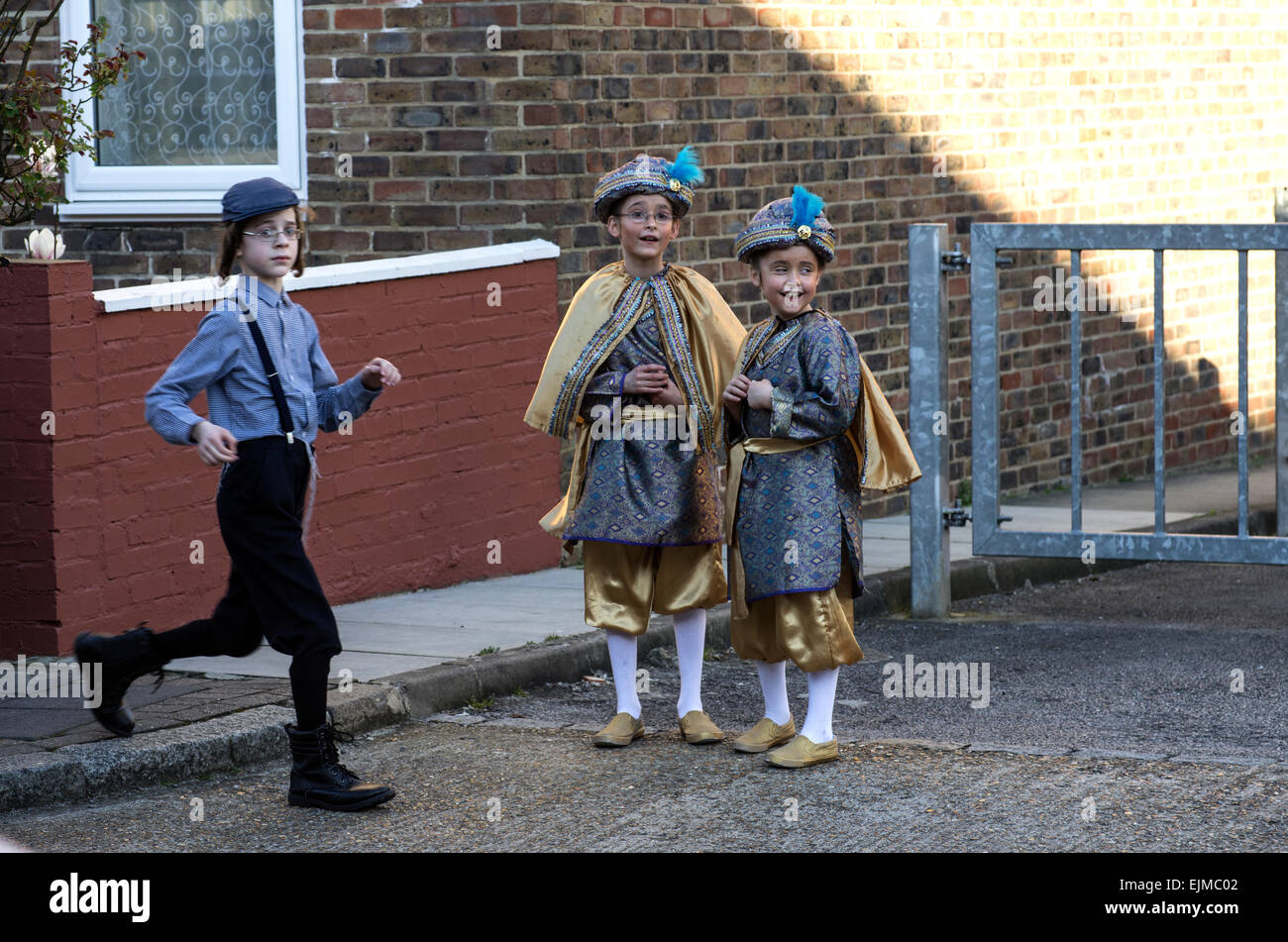 Three children in fancy dress costumes for the Jewish holiday of Purim ...