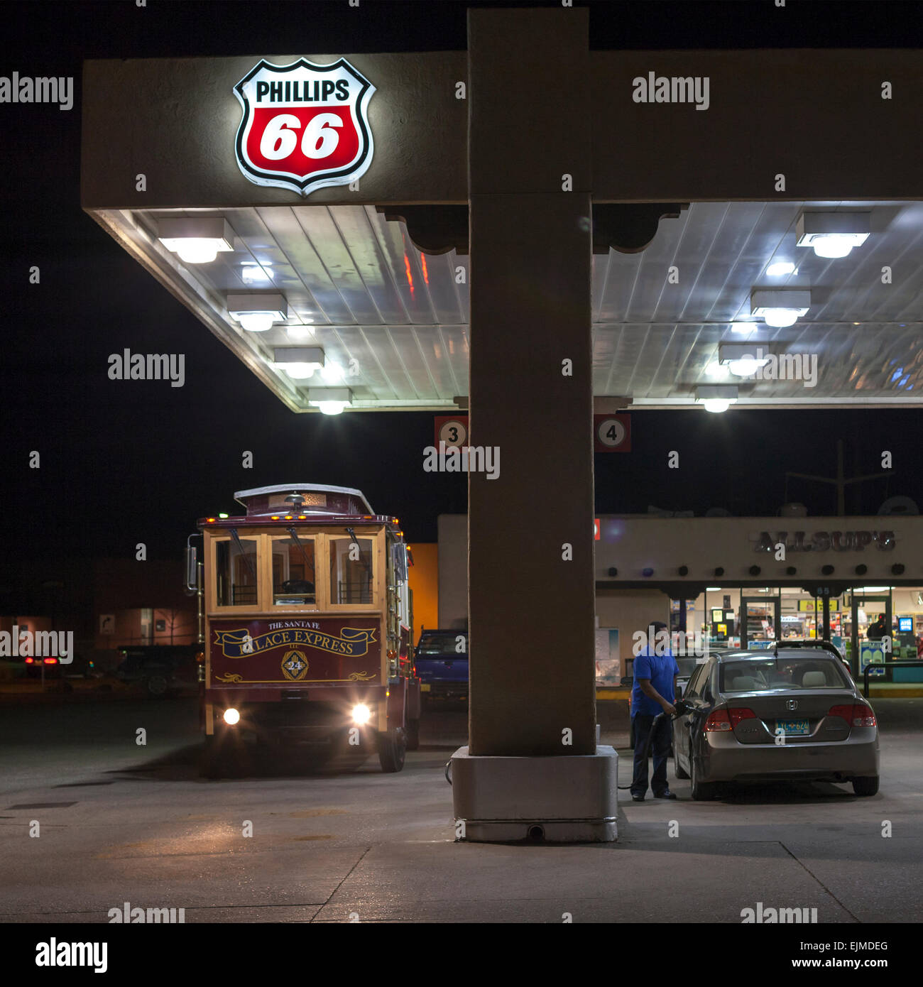 A man pumps gas at night at a Phillips 66 station in Santa Fe, New ...