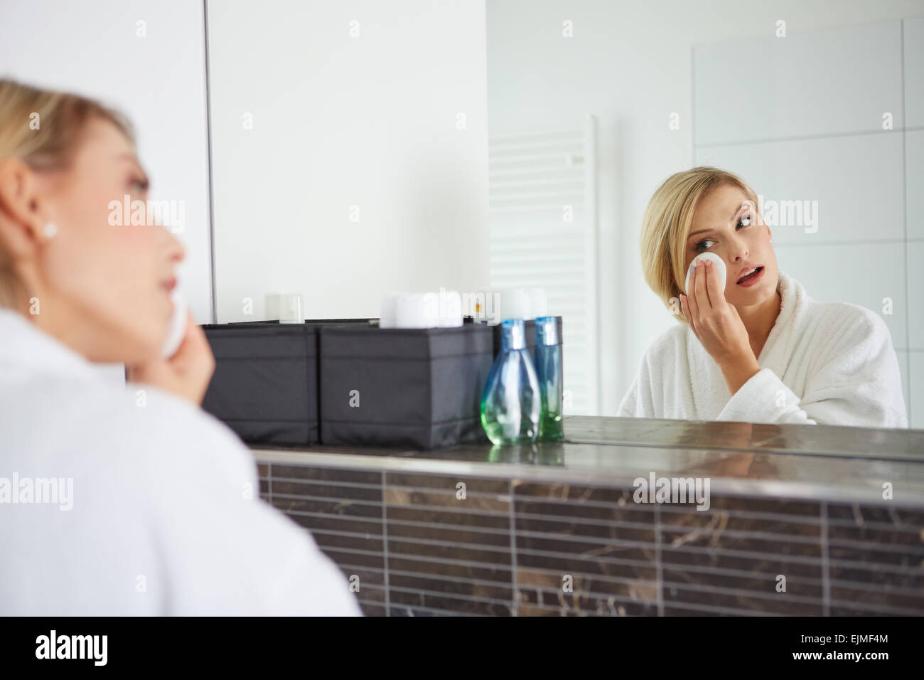 Woman removing makeup from her face Stock Photo - Alamy